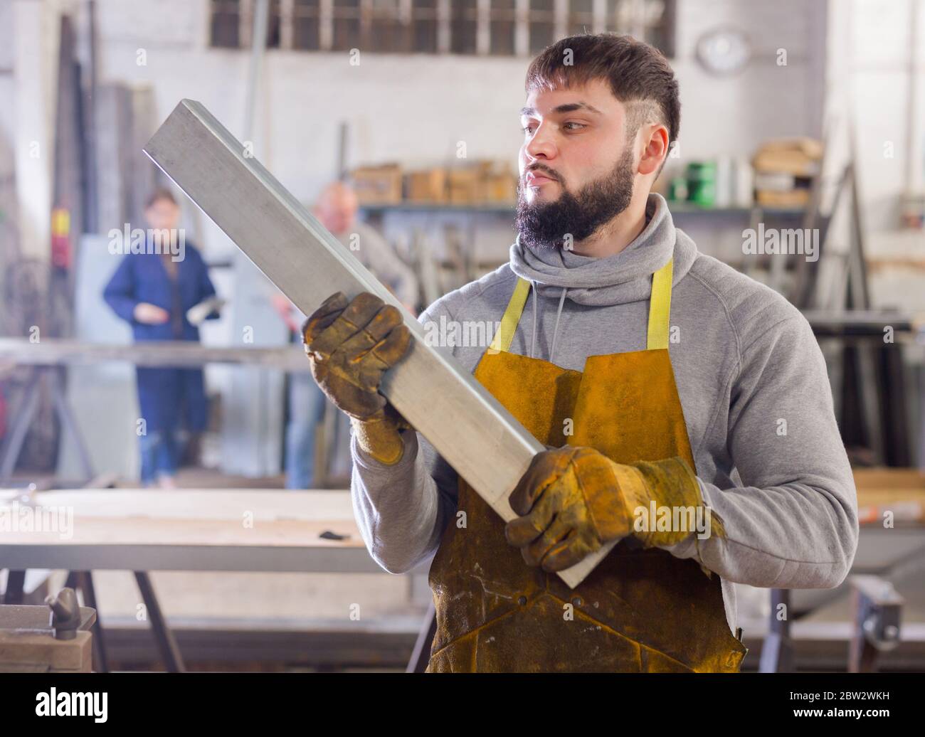 Male worker controls the size of a metal profile pipe Stock Photo - Alamy