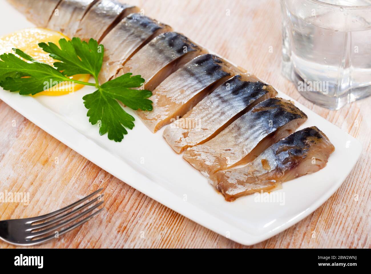 Image of cut lightly salted mackerel fish served with lemon and greens ...