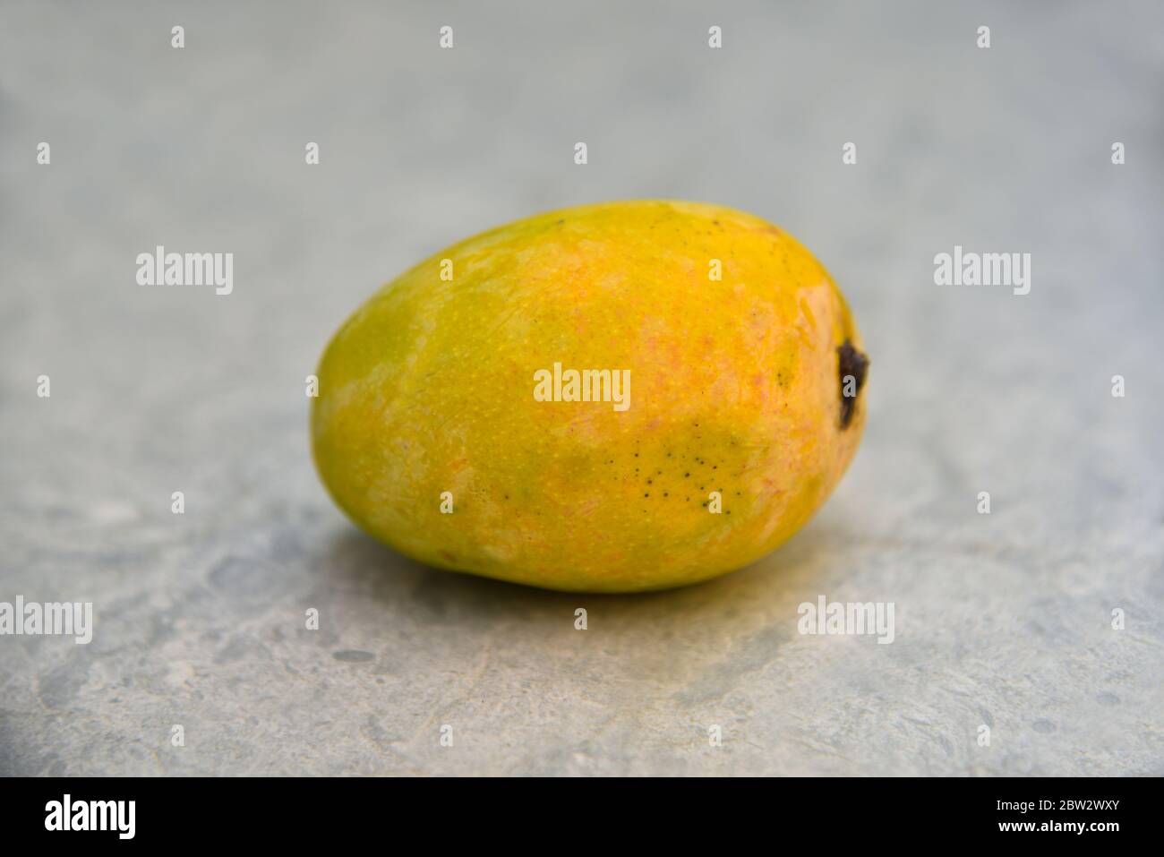 one mango fruit on texture background Stock Photo - Alamy
