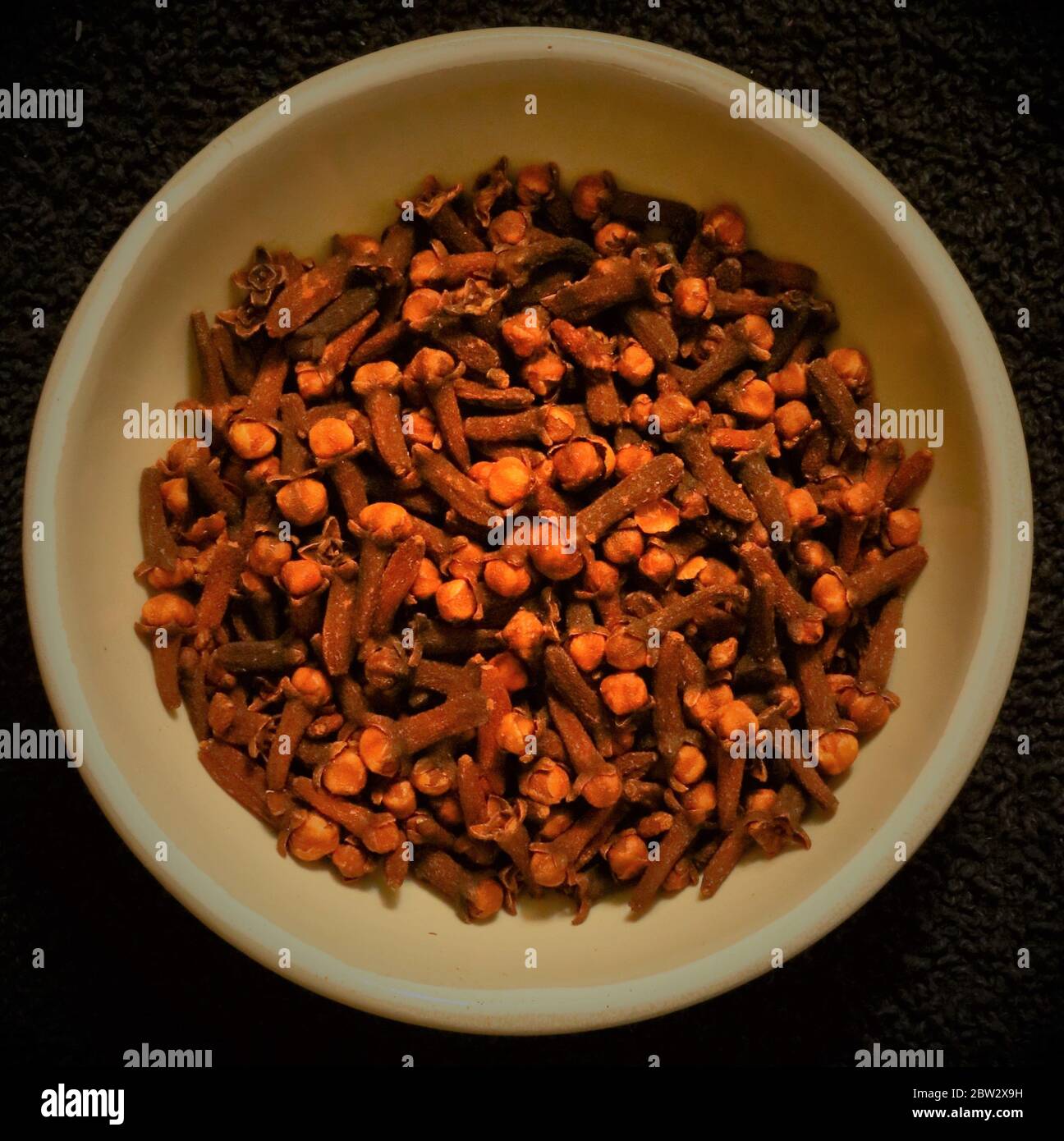Whole cloves in a small bowl Stock Photo - Alamy