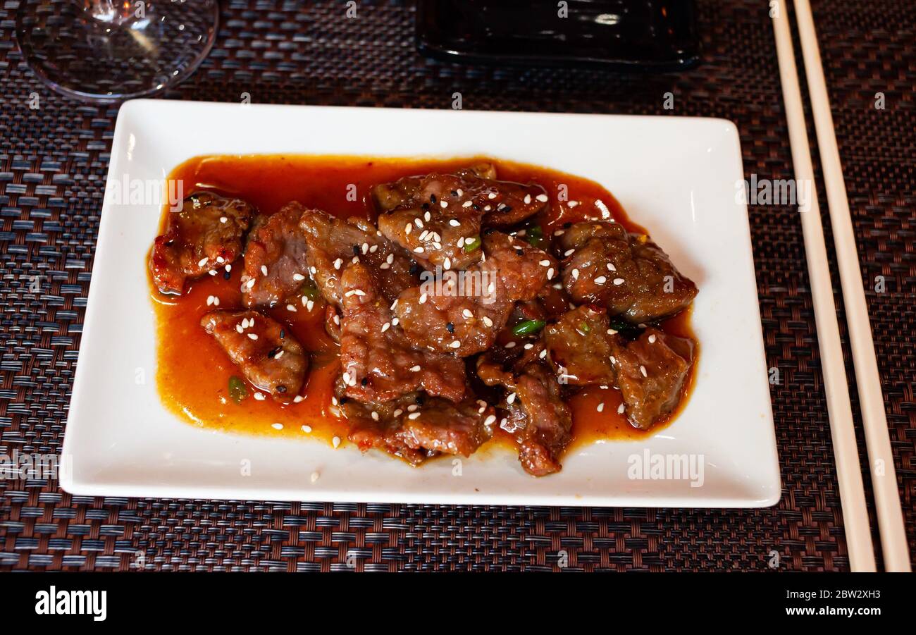 Spicy stewed beef fillet cooked in wok with soy sauce, greens and ...