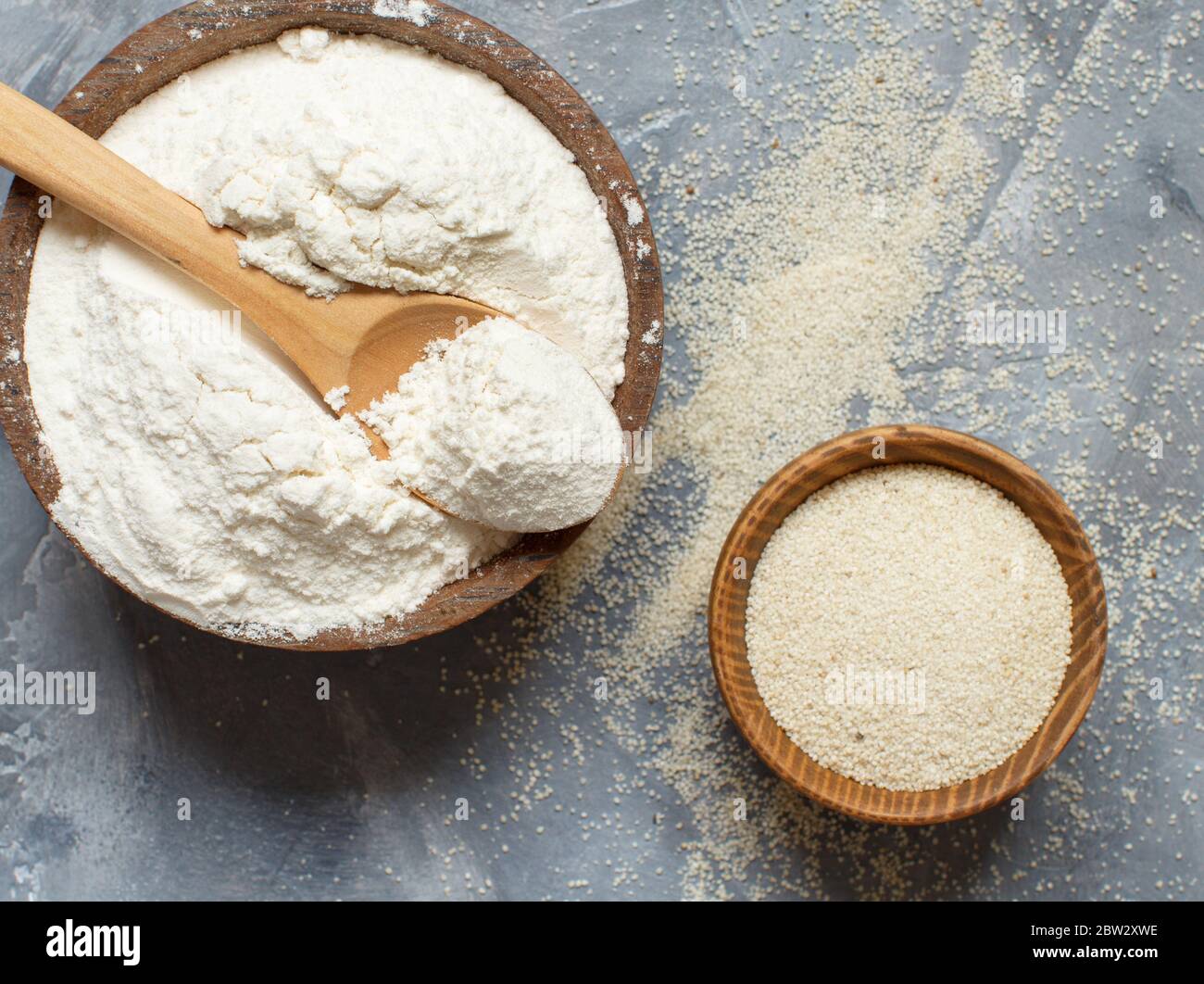 Raw fonio flour and seeds with a spoon on grey background top view. Alternative flour Stock ...