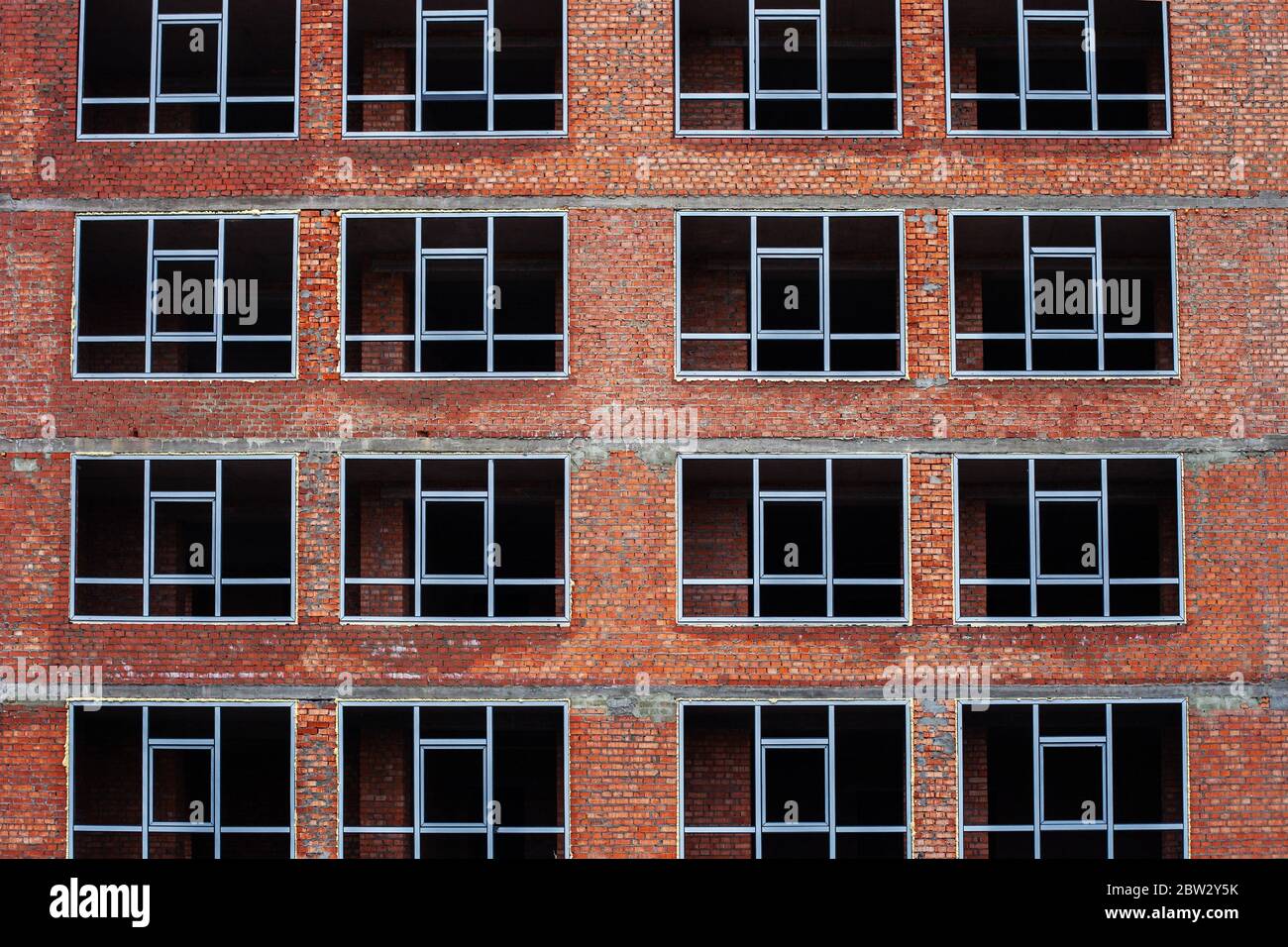Windows frame in brick multistory house under construction. Part of ...
