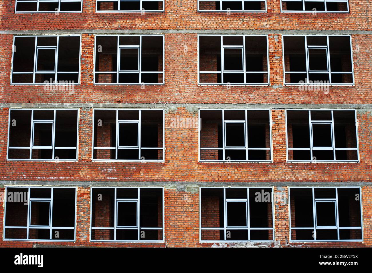 Window frame in brick multistory house under construction. Part of ...