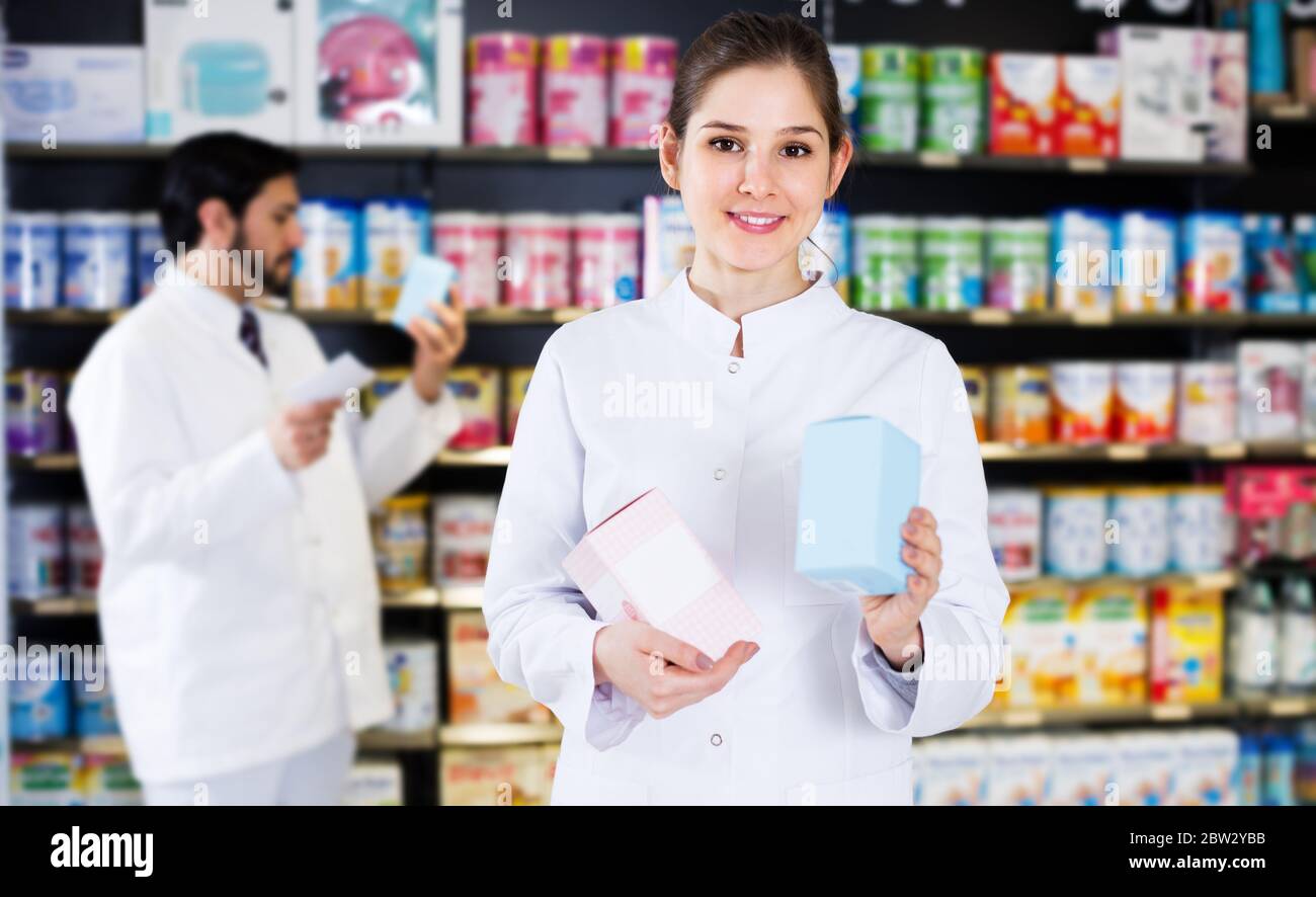 Smiling female pharmacist is standing with medicines in pharmacy Stock ...