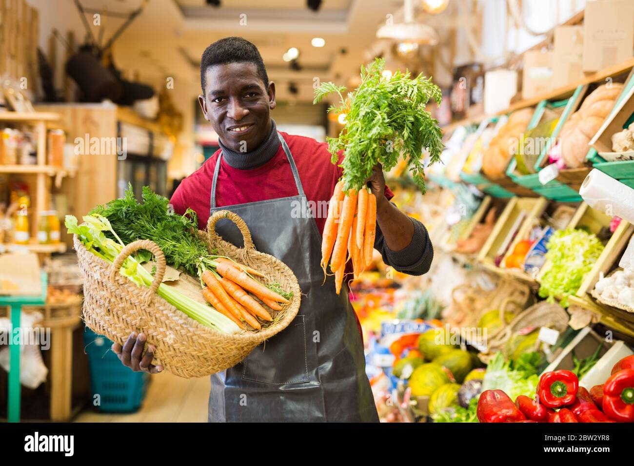Positive African American man owner of greengrocery shop in apron ...