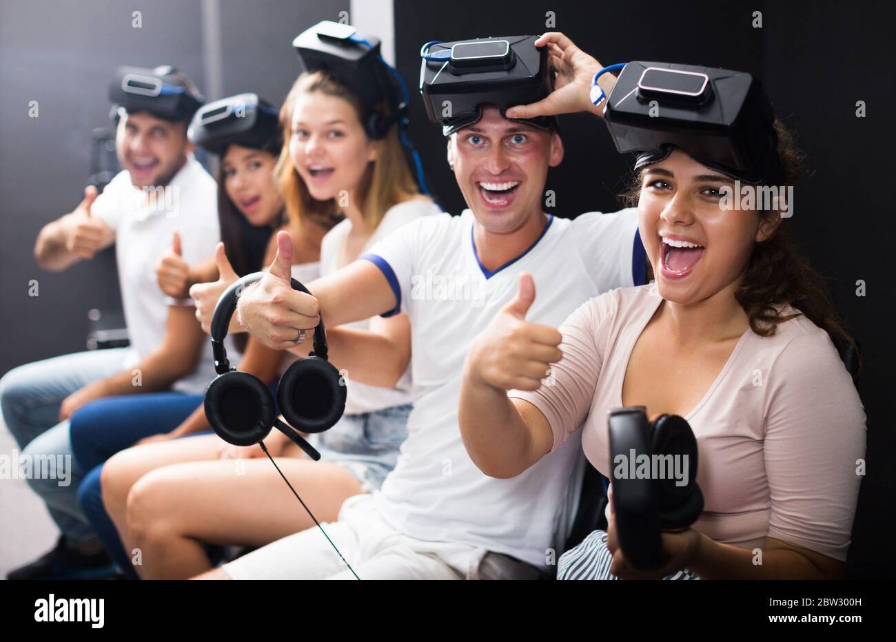 Happy young people expressing satisfaction with vr attraction showing ...