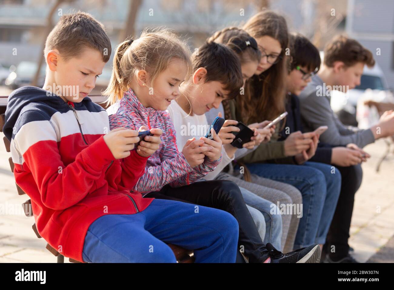 Kids using phones outdoors, concept of children addiction to social ...