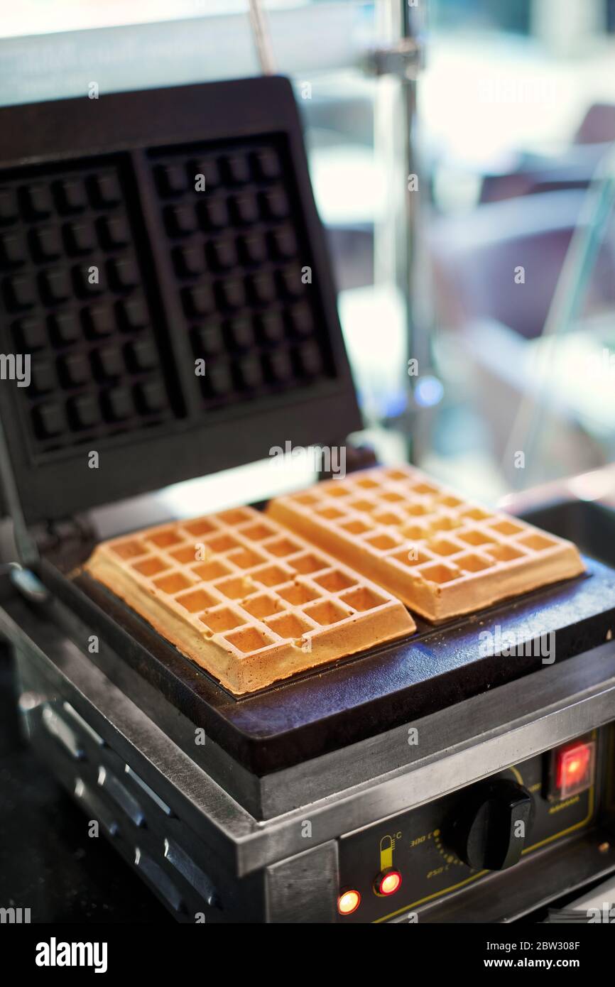 Freshly baked waffles in a professional waffle machine Stock Photo - Alamy