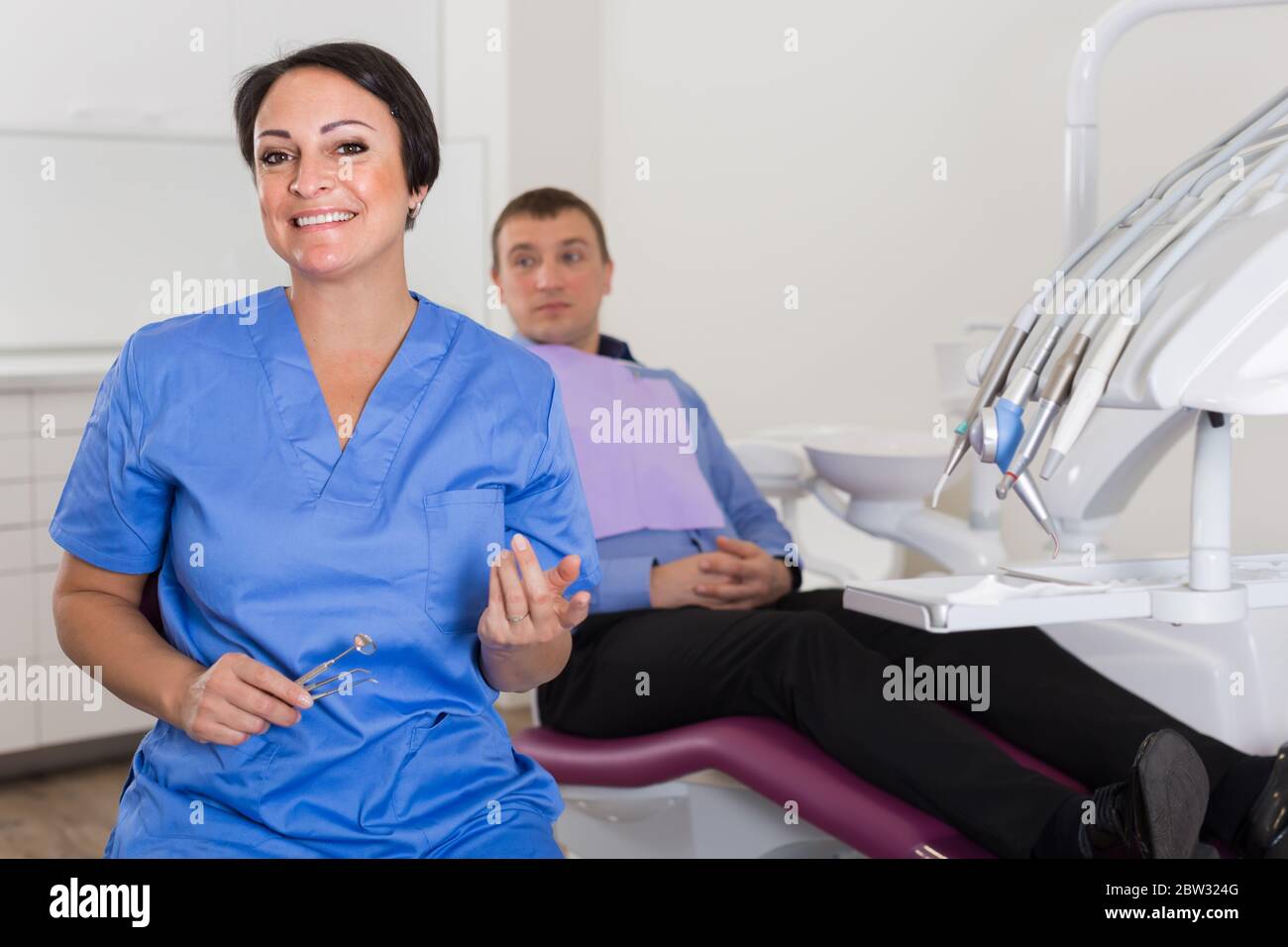 professional positive doctor woman and patient sitting in medical chair ...