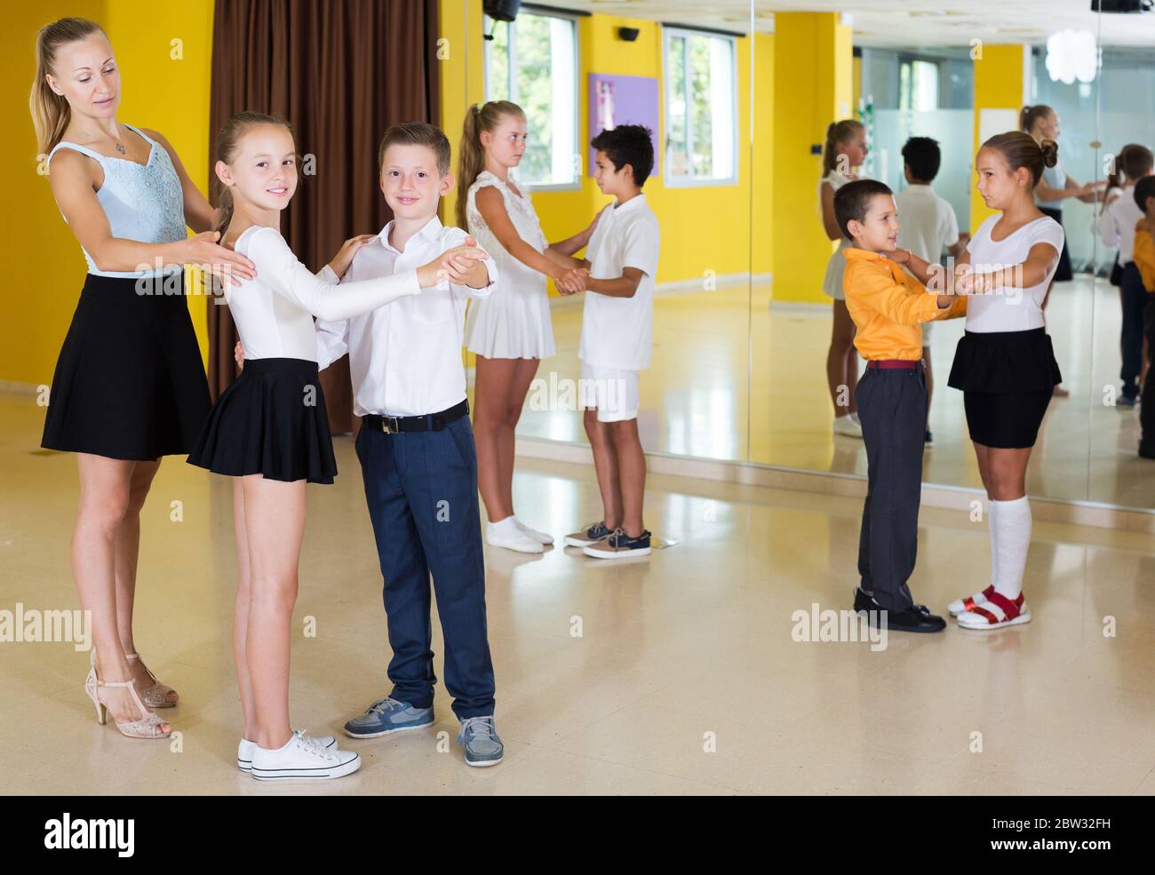 Positive young children enjoying of partner dance in class Stock Photo ...