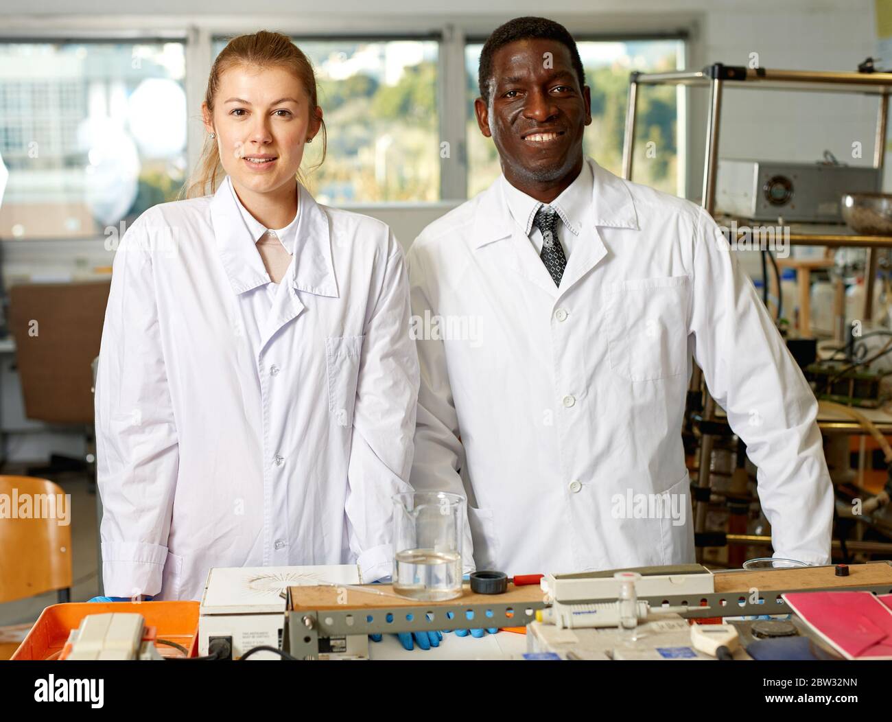 Portrait of proffesional male and female lab cientists in interior of ...