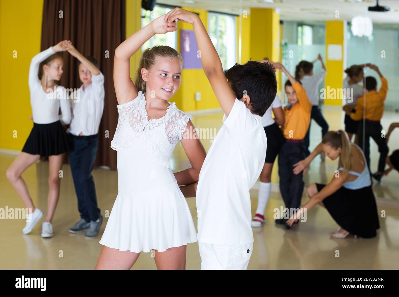 Active smiling young children enjoying of partner dance in class Stock ...
