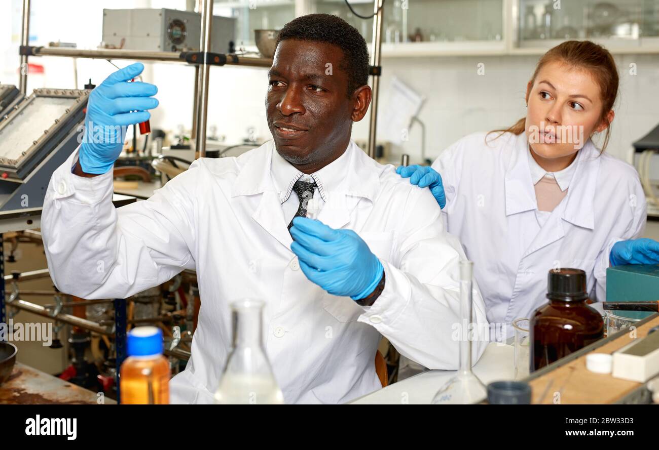 Worried lab technicians checking for result of unhappy experiment in ...