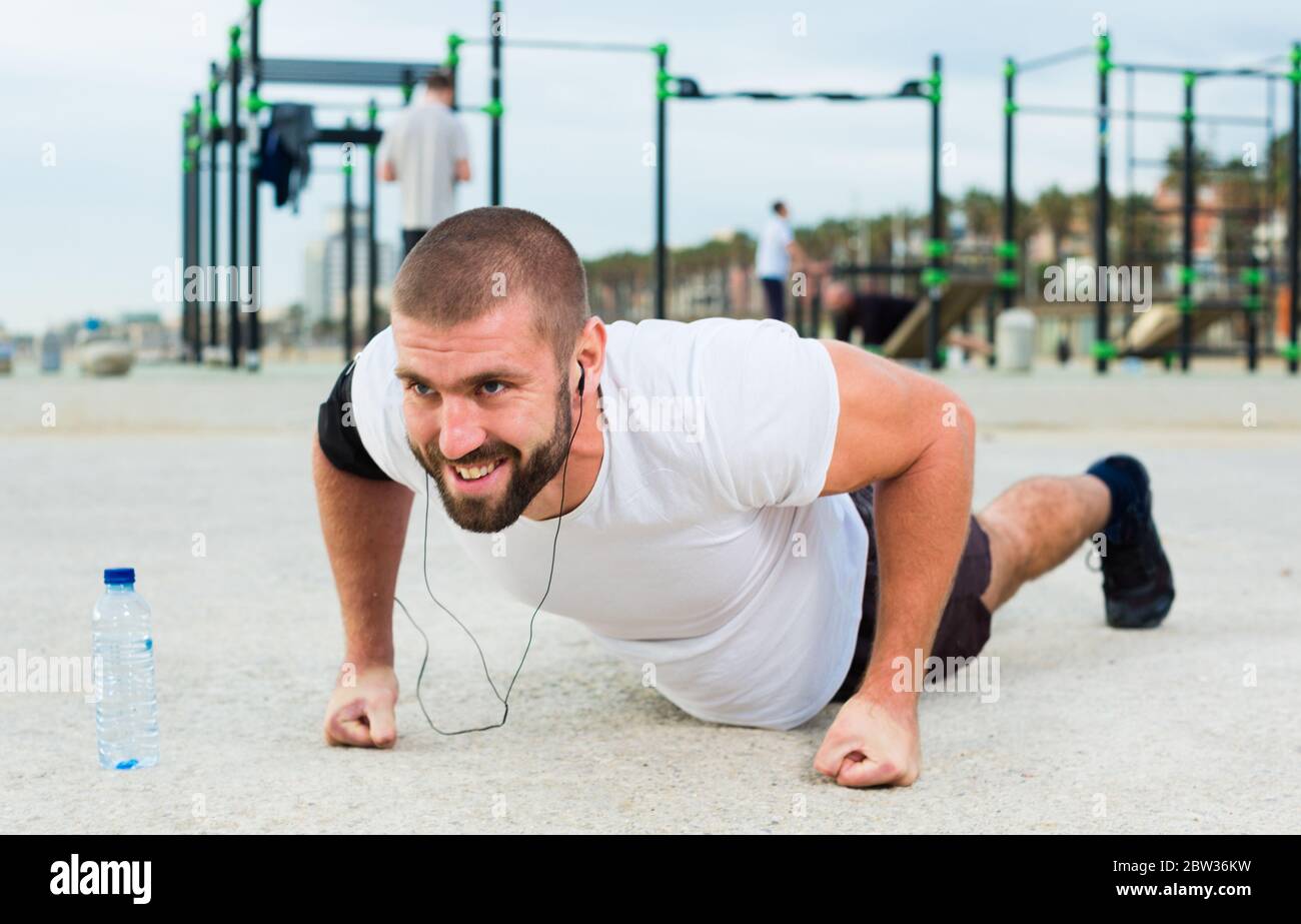 Strong man performs push-ups on an outdoor sports field Stock Photo - Alamy