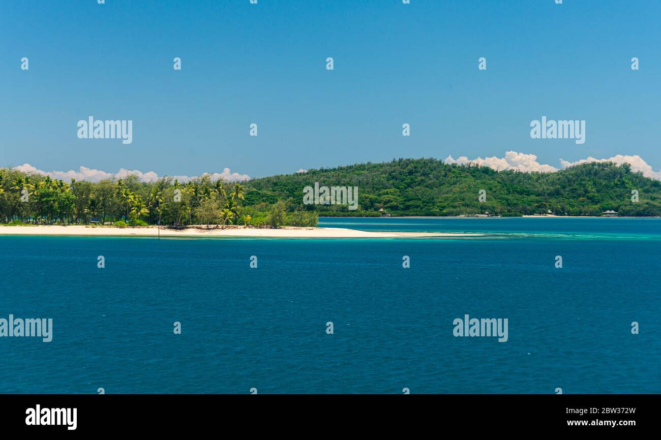 Wide angle view of an island with palm trees and white sandy beach ...