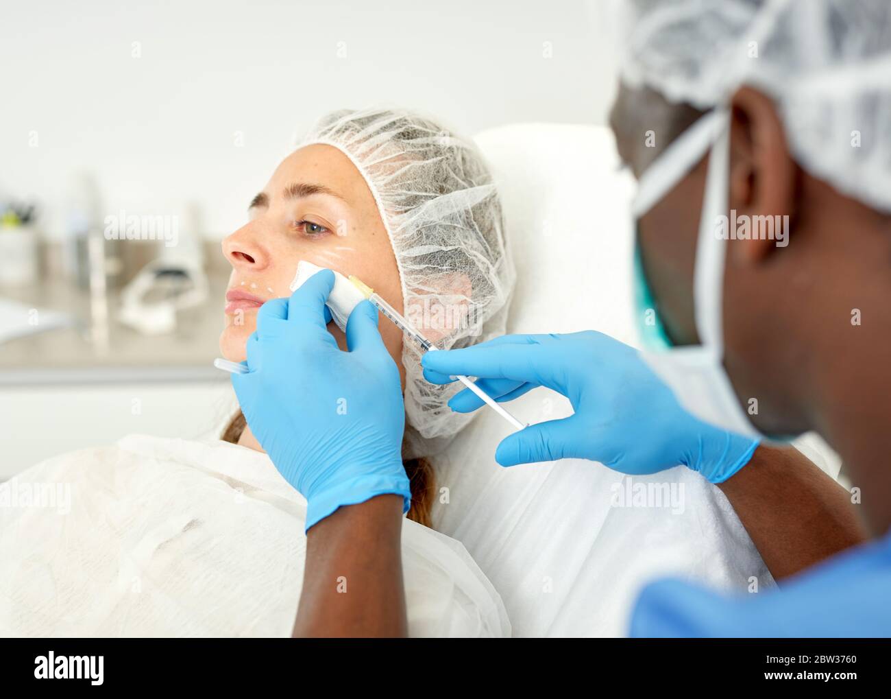 Portrait of woman client and doctor during beauty facial injections in ...