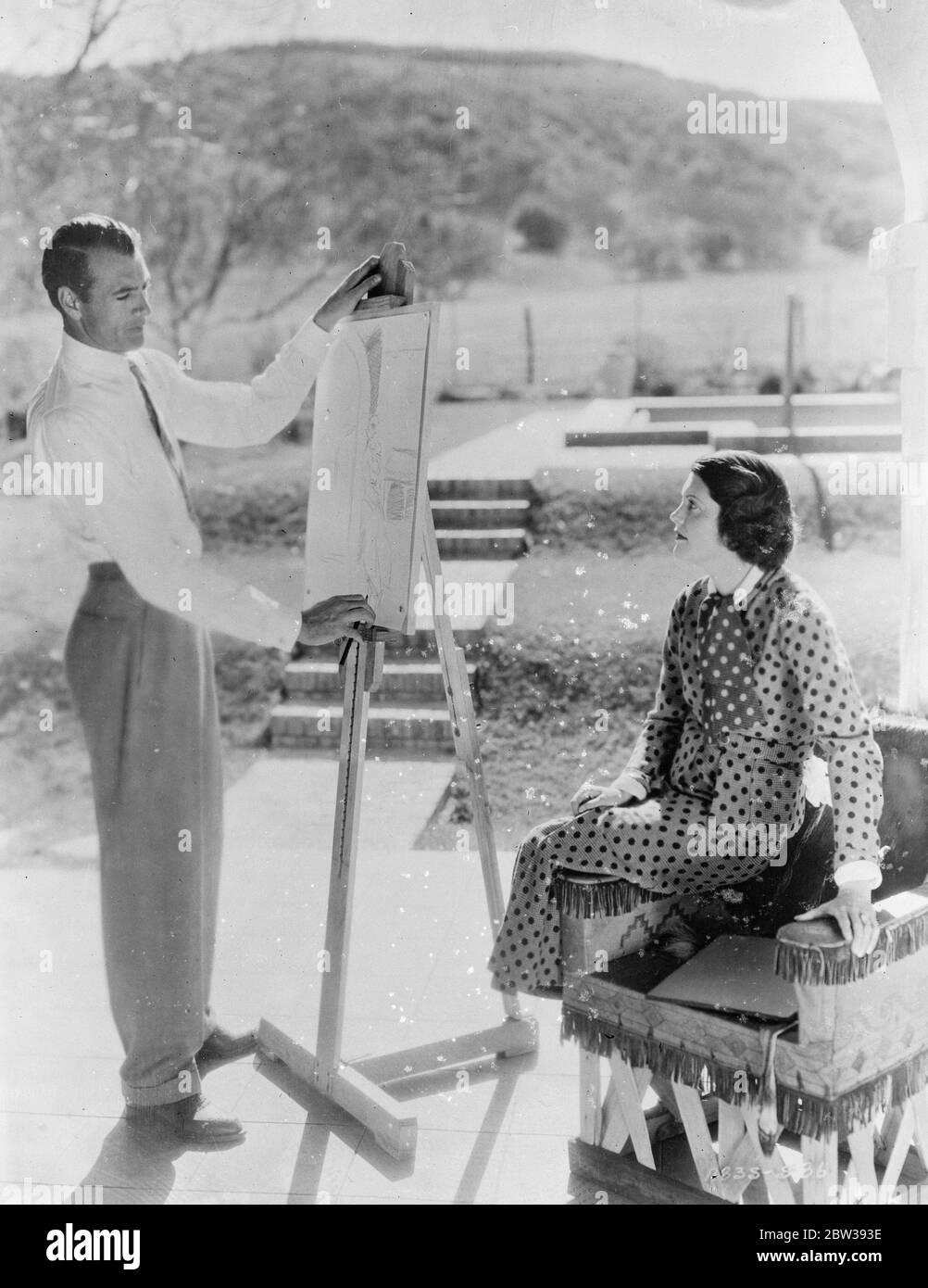 Gary Cooper tests his skill with the pencil on a society girl as his ...