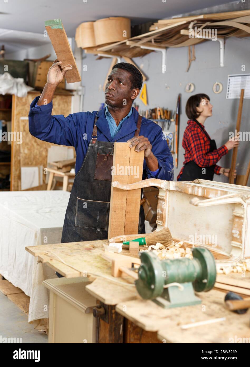 Portrait of male and female artisans in process of renewing vintage ...