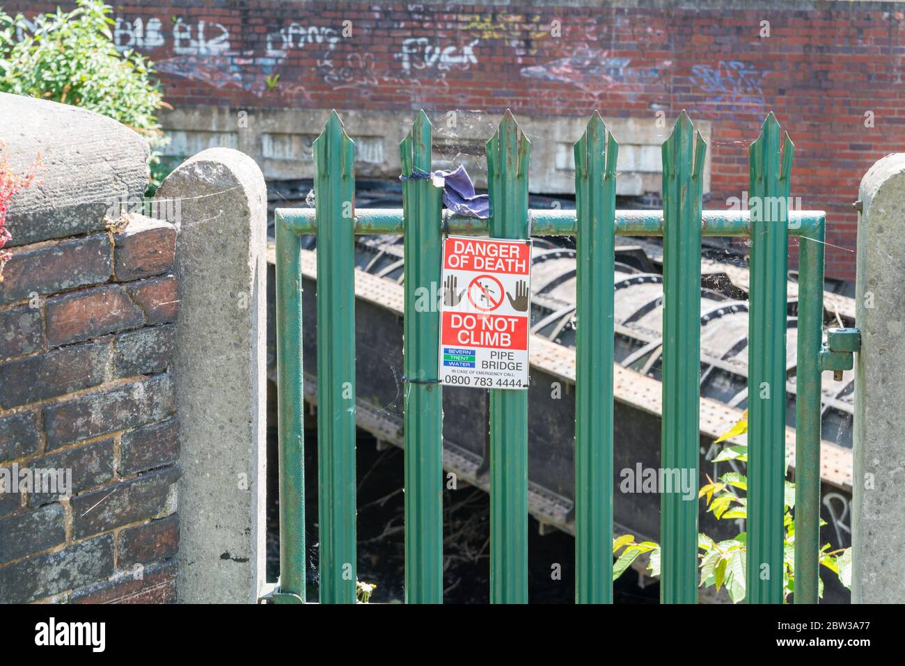 Warning sign beside a pipe bridge on the Birmingham and Fazeley Canal ...