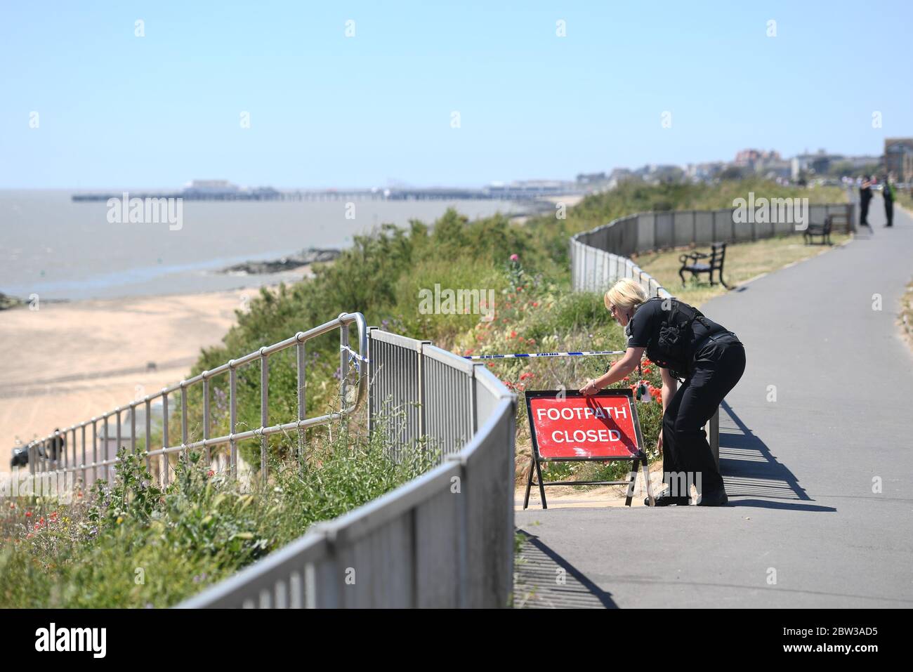 A police officer places a sign blocking access to a beach where a 40ft ...