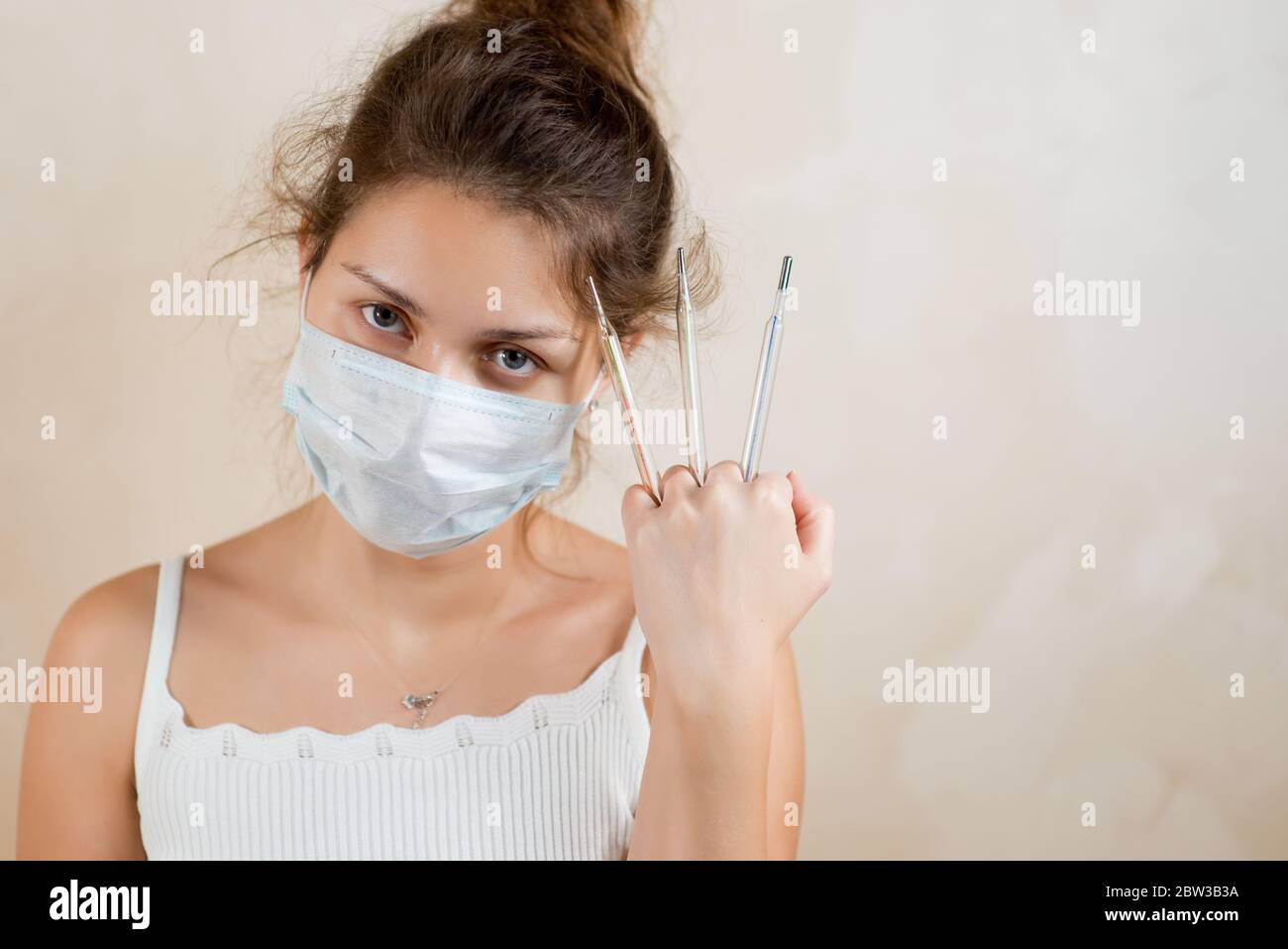 a sickly-looking woman and thermometers in her fist, Copy space Stock ...