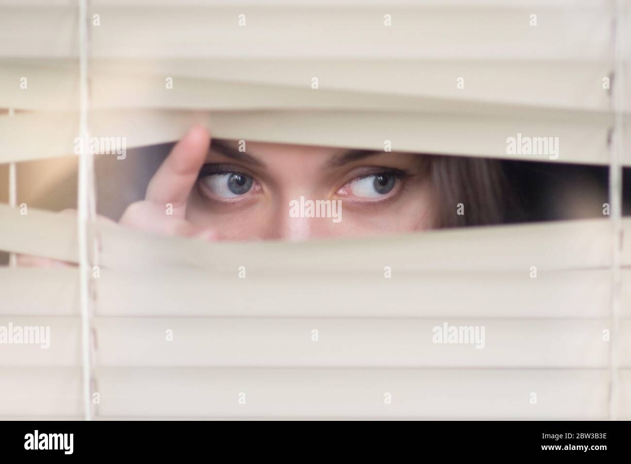 Peeping out window woman hi-res stock photography and images - Alamy