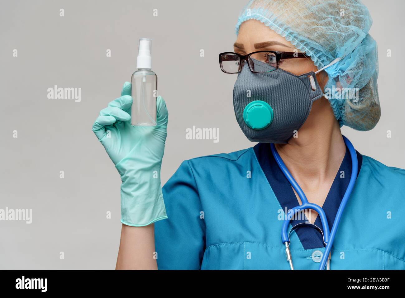 medical doctor nurse wearing protective mask - holding bottle of ...