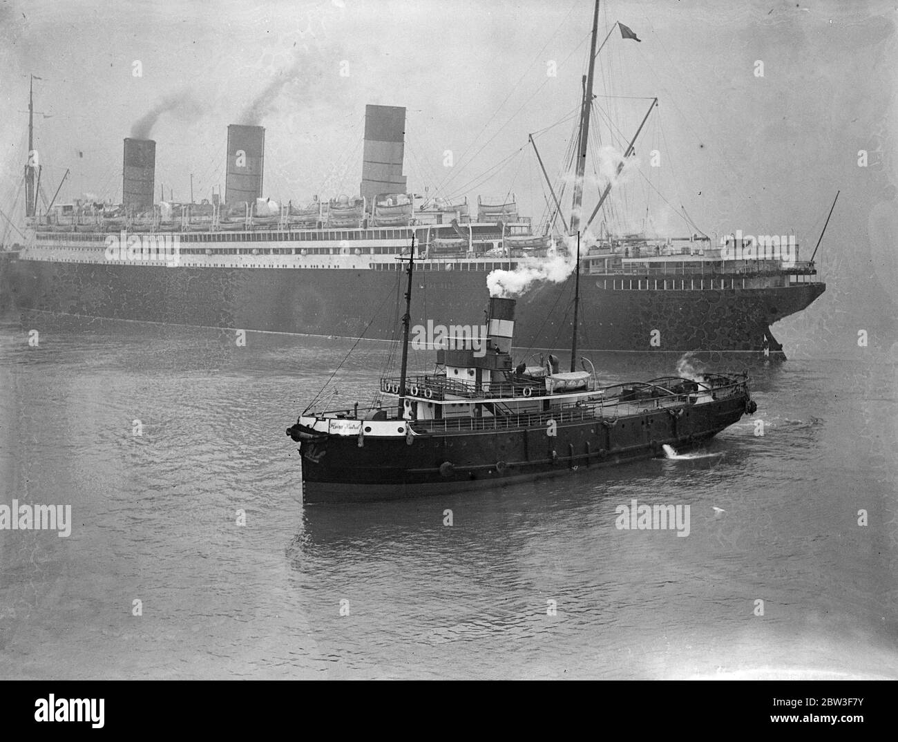 Berengaria of the Cunard fleet under the watchful eyes of the tug ...
