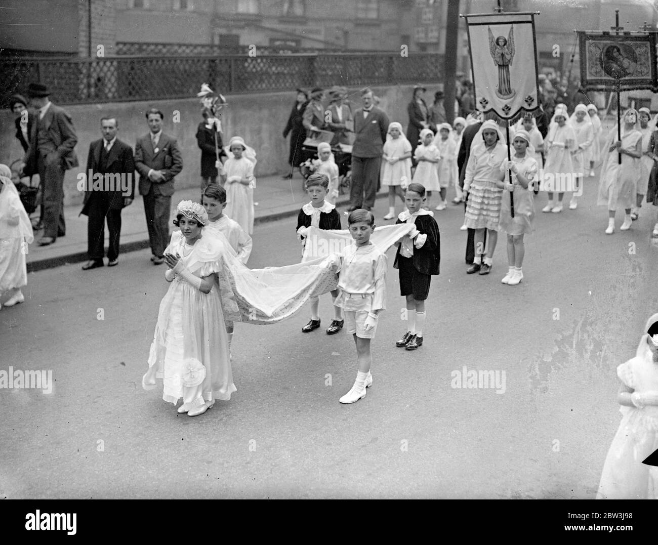 May Queen walks in catholic procession . Through Shepherd ' s Bush . In ...