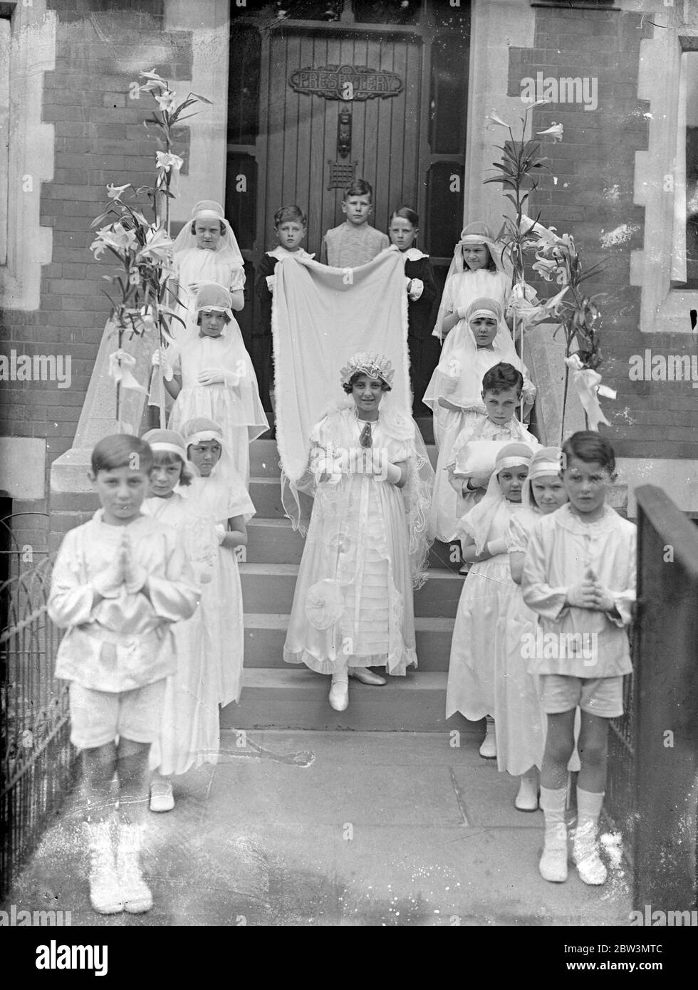 May Queen walks in catholic procession . Through Shepherd ' s Bush . In ...