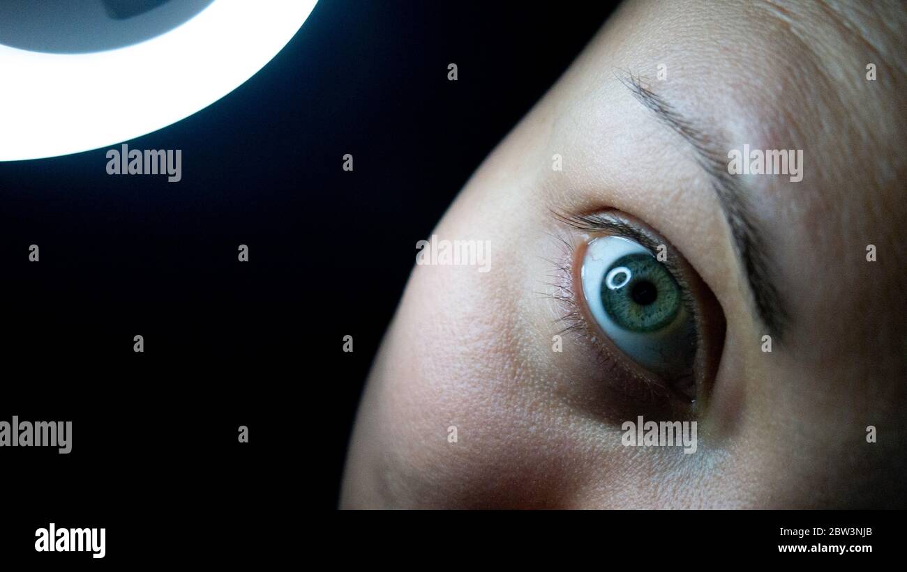 A light pointed at a woman's green eye. Healthy eyes of a young girl ...