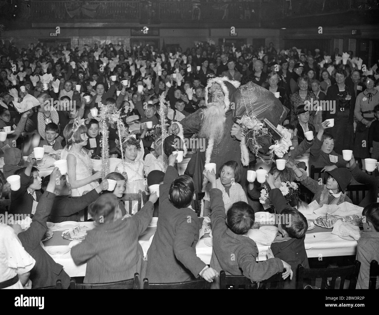 Santa Claus pours tea at children 's party at Paddington Baths Hall ...