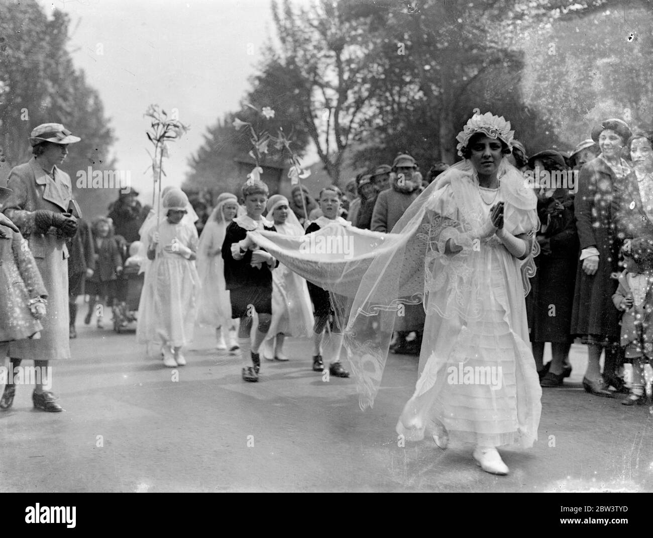 May Queen walks in catholic procession . Through Shepherd ' s Bush . In ...