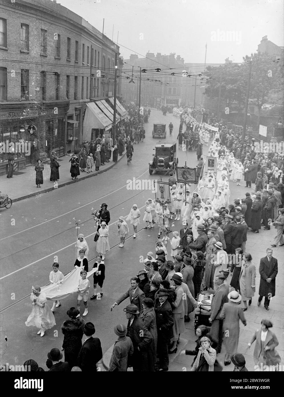 May Queen walks in catholic procession through Shepherd ' s Bush . In a ...