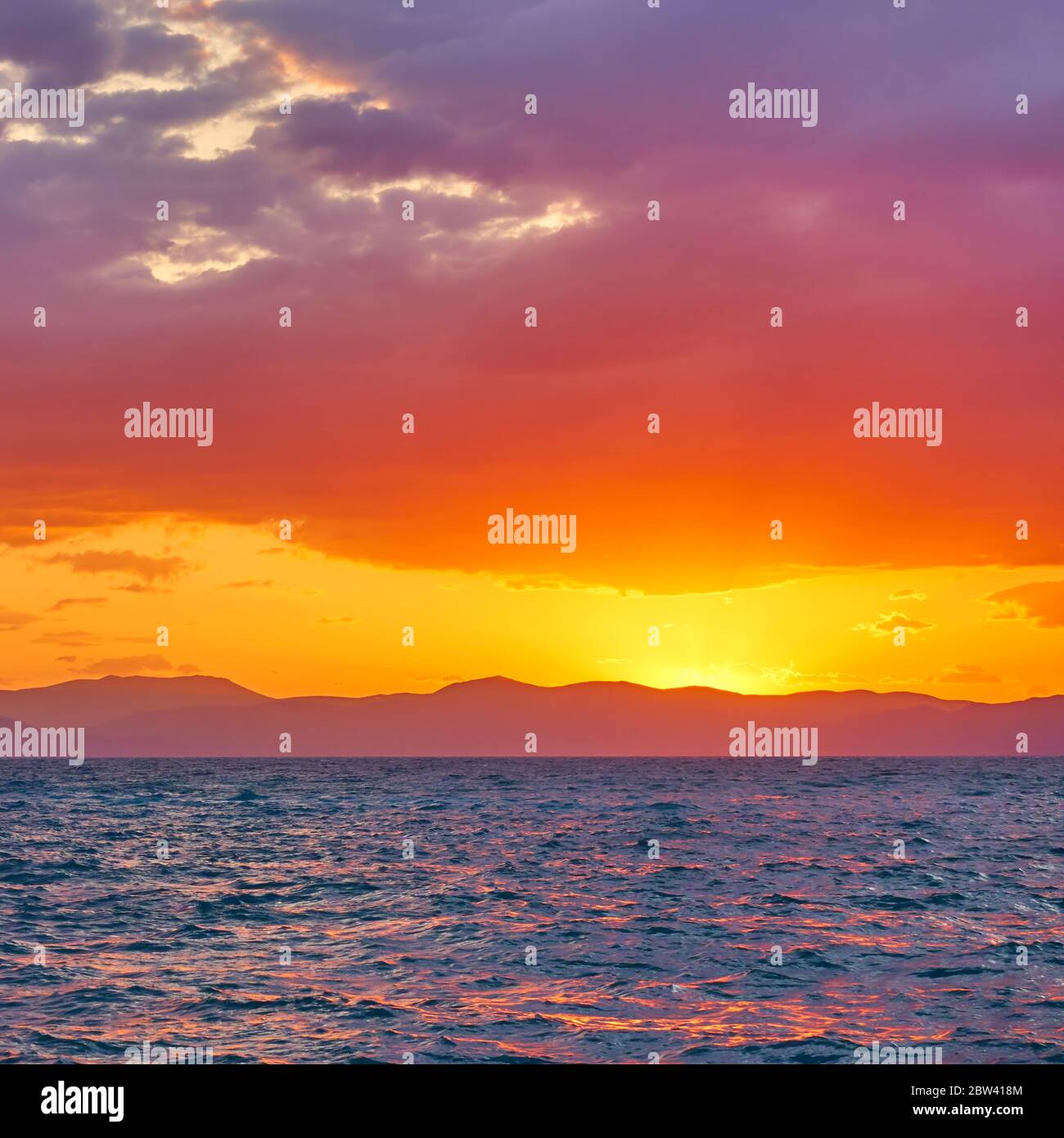 Glowing yellow red sky with clouds aloft the sea at sunset - Colorful ...