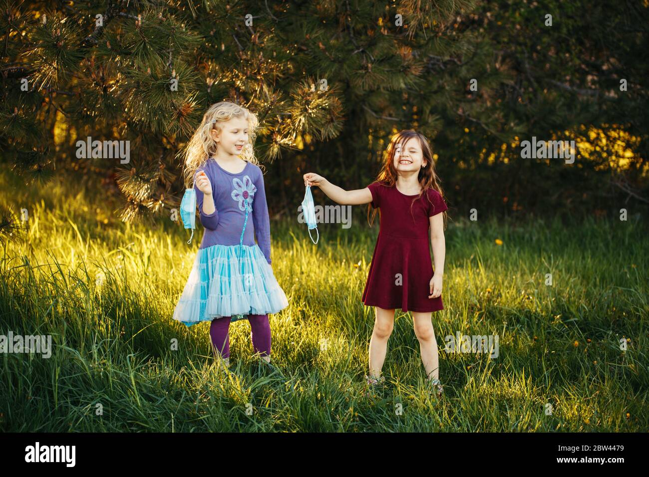 Cute happy girls friends holding sanitary masks. Funny smiling ...