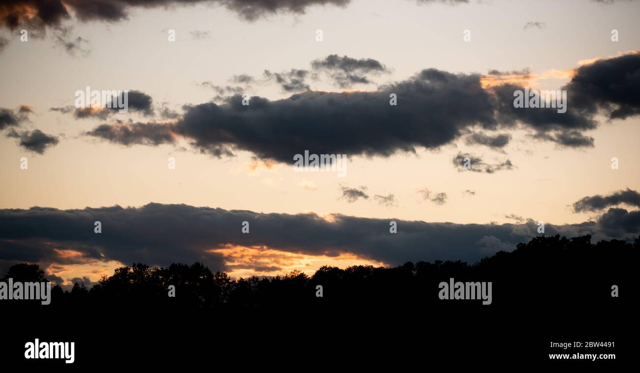 Sunset over forest with dramatic sky and colorful dark clouds Stock ...