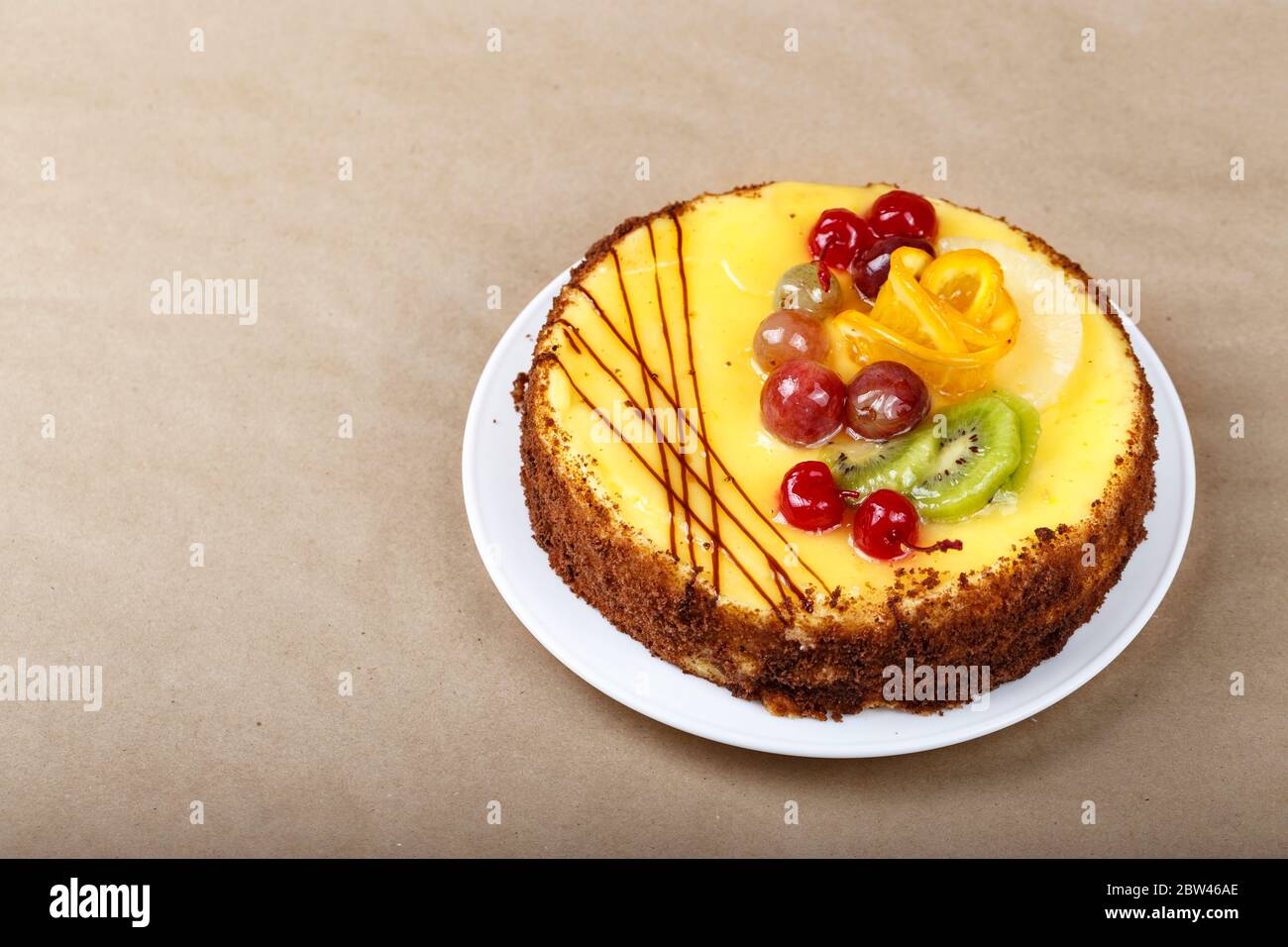 cake with cream and berries on craft paper, place for text. traditional ...