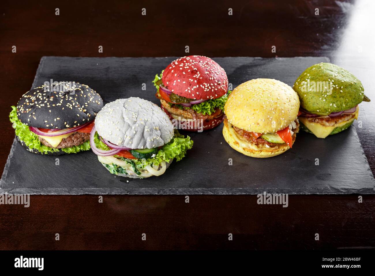 burgers in colorful buns. assortment of meat burgers with vegetables ...