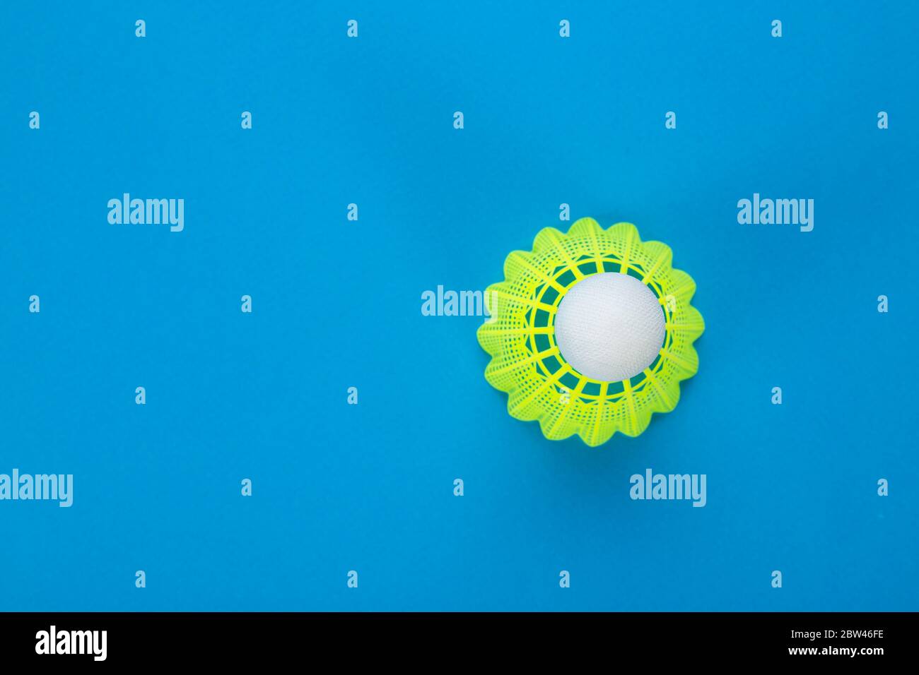 light green shuttlecock for badminton on a blue background, place for ...