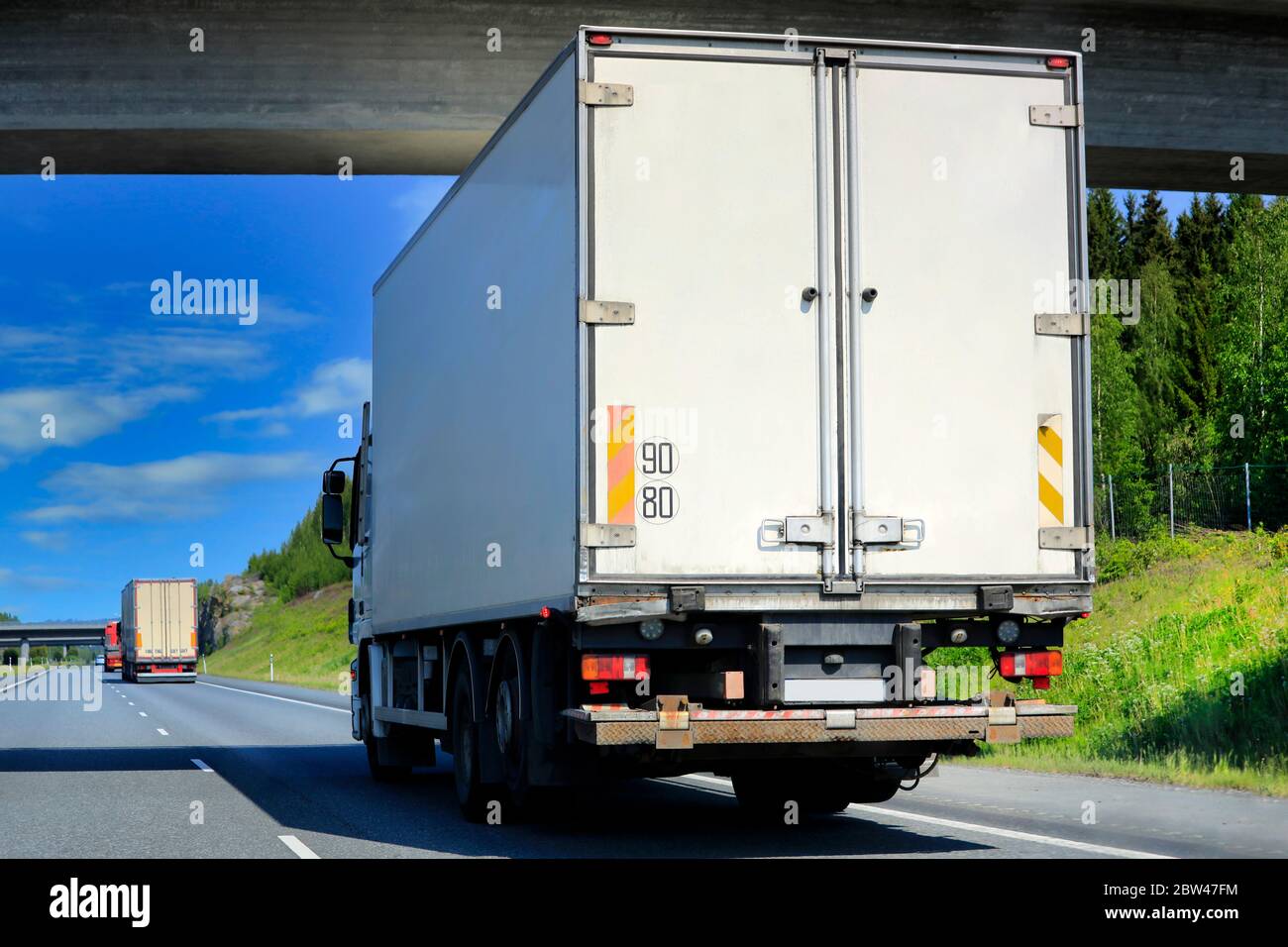 White delivery truck transporting goods on motorway with other freight ...