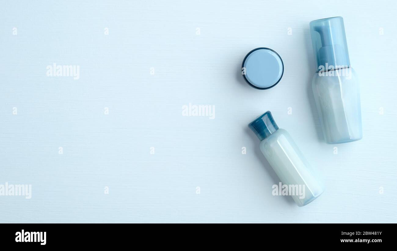 Blue cosmetic bottles and cream jar on blue background. SPA natural ...