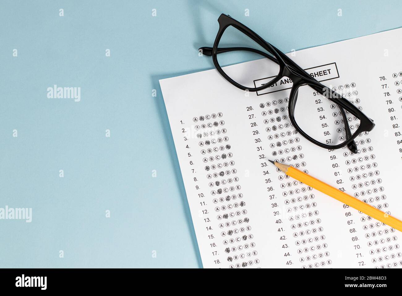 Take the exam, write the exam. Exam paper on blue background, top view ...