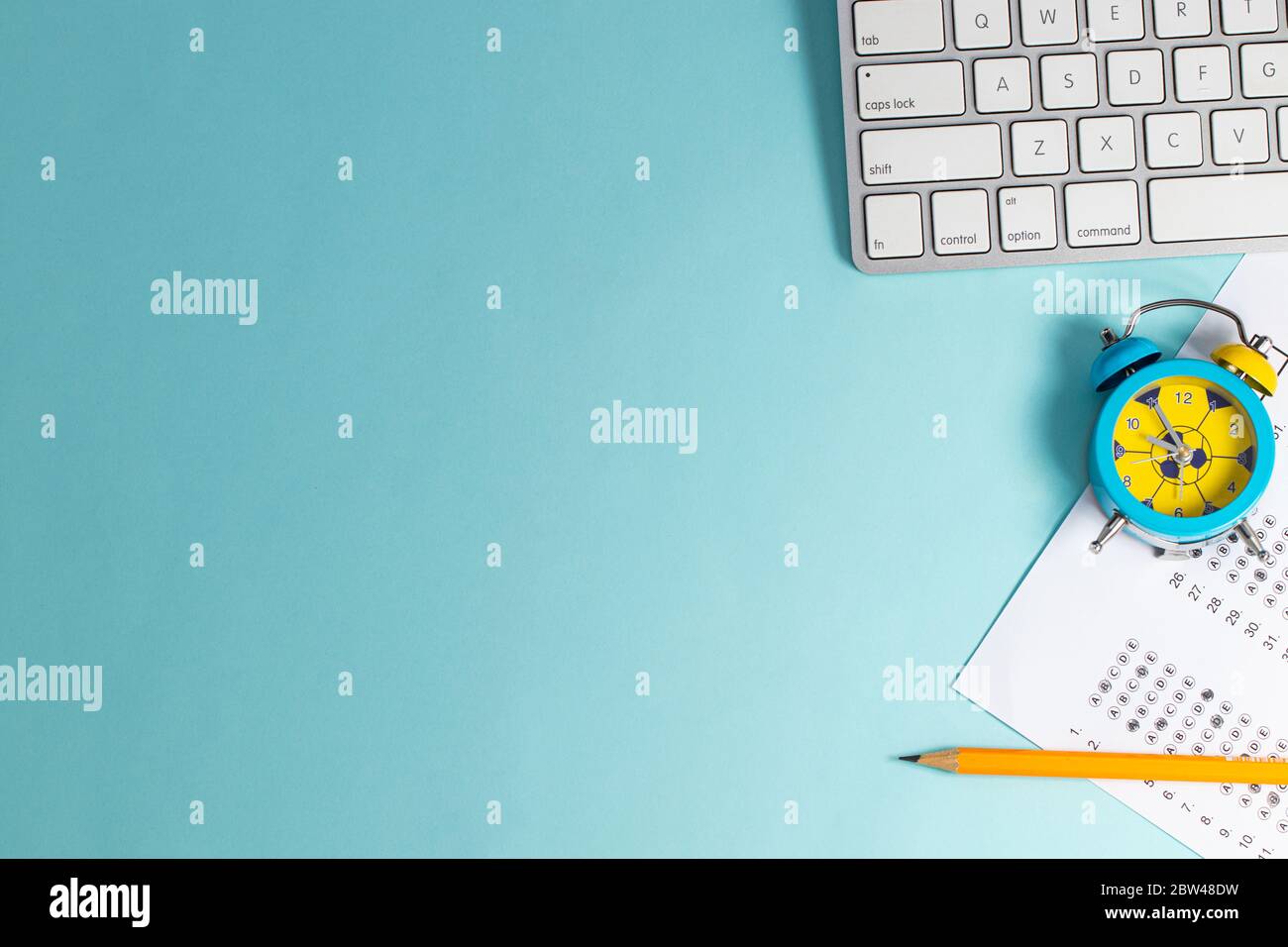 Take the exam, write the exam. Exam paper with alarm clock on blue ...