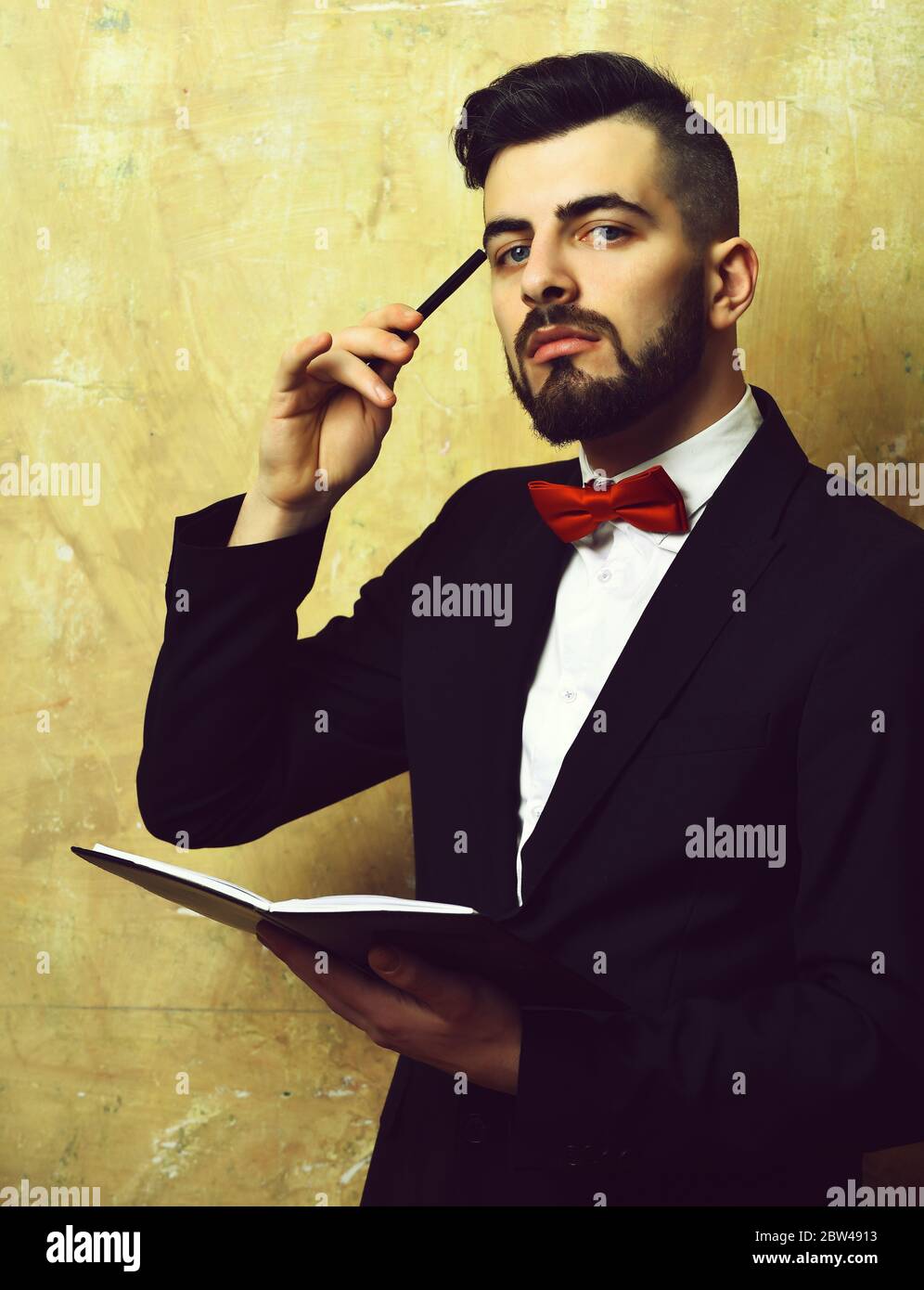 Young insurance agent with neat beard and concentrated look thinks of ...