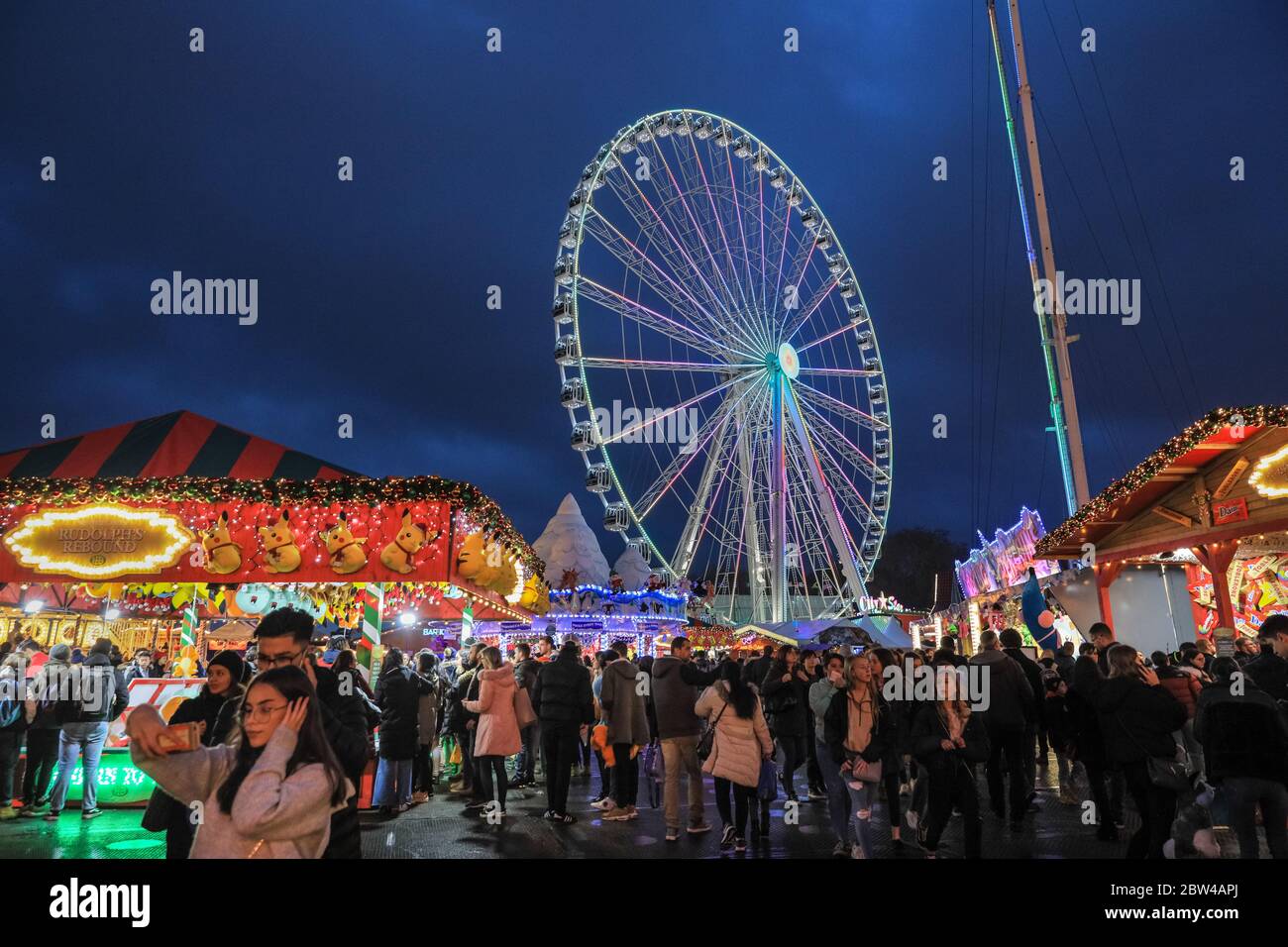 Illuminated evening christmas market with stalls and ferris wheel hi ...