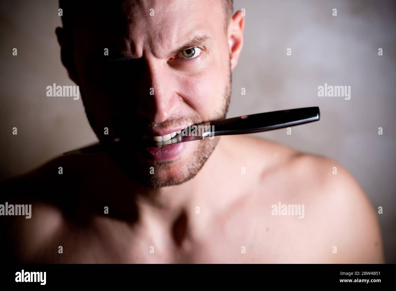 man holding a knife in his teeth Stock Photo - Alamy