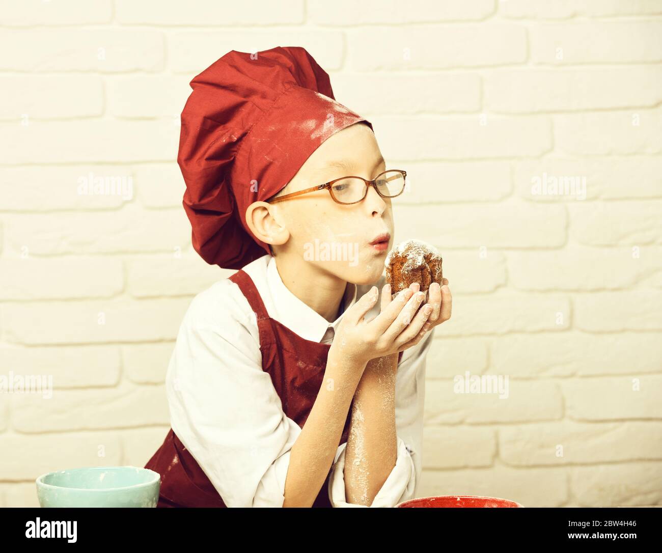 young boy cute cook chef in red uniform and hat on stained face with ...