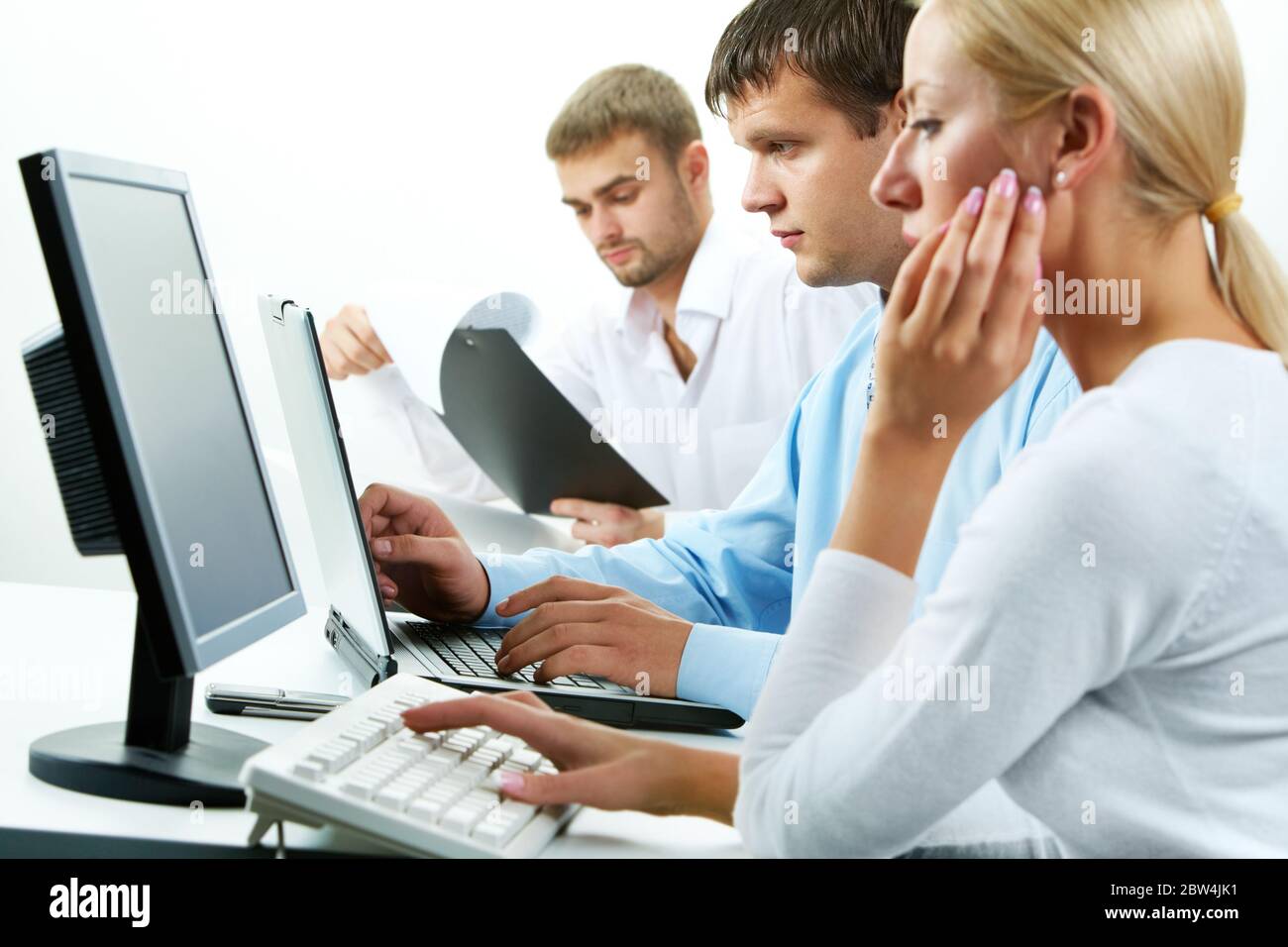 Image of serious business partners typing in working environment Stock ...